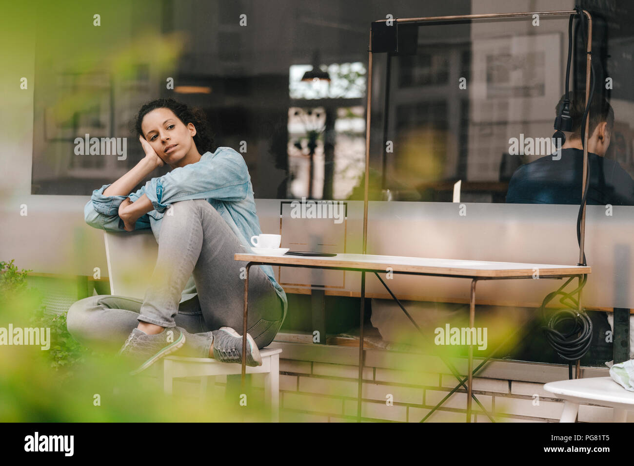 Tired woman resting in front of coffee shop Stock Photo - Alamy
