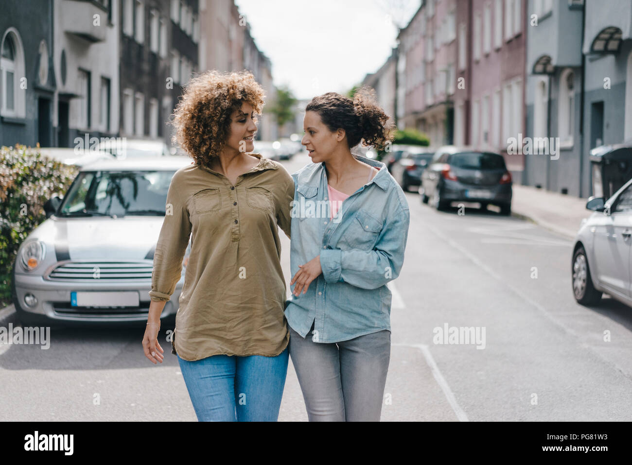 Best friends walking in the city, arm in arm Stock Photo - Alamy