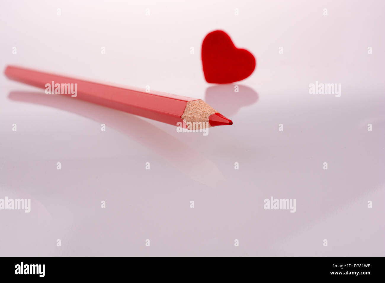 Pencil pointing a red heart Stock Photo - Alamy