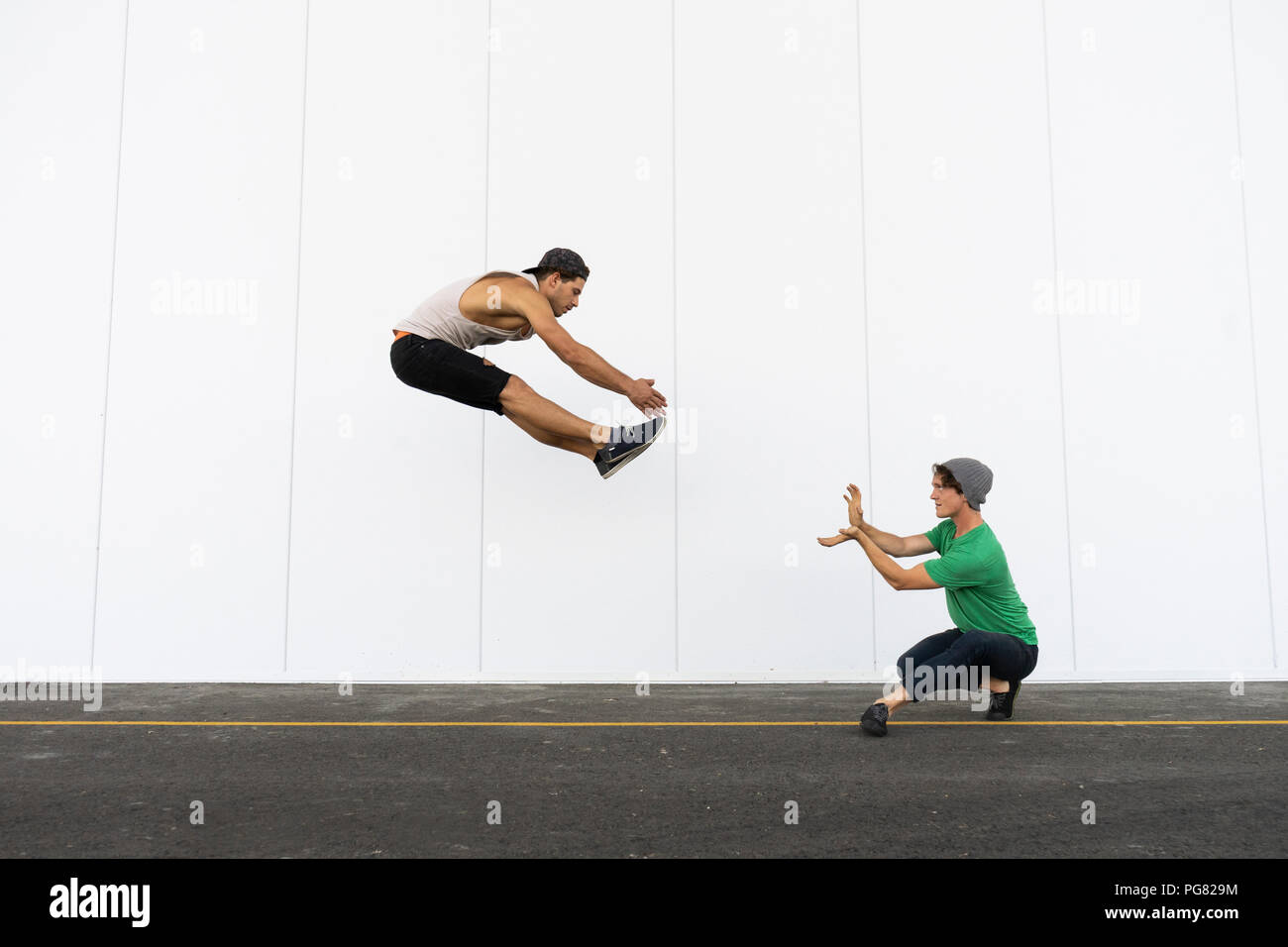 Two acrobats doing tricks together, jumping mid-air Stock Photo - Alamy