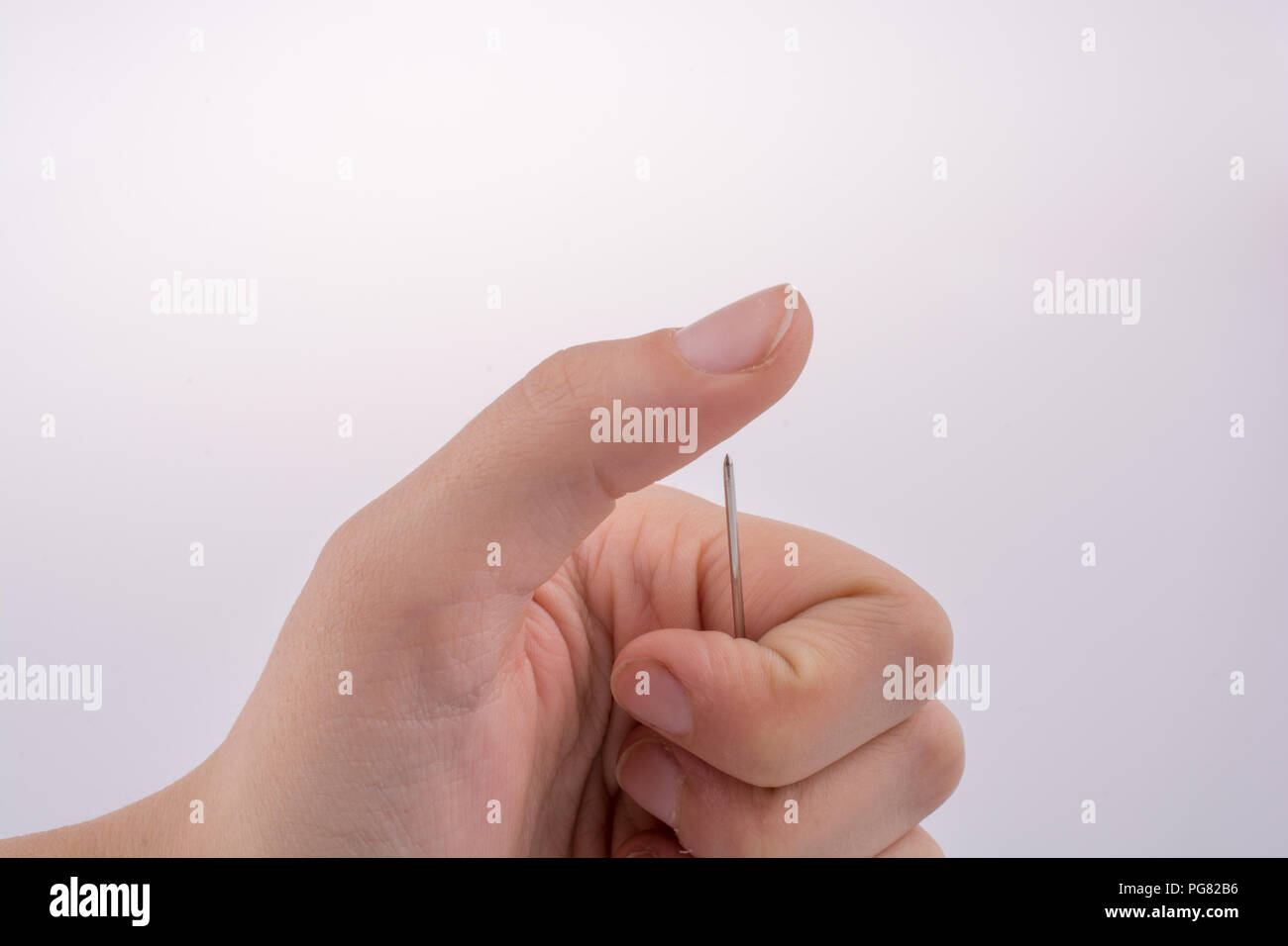 Hand holding a needle on a white background Stock Photo - Alamy