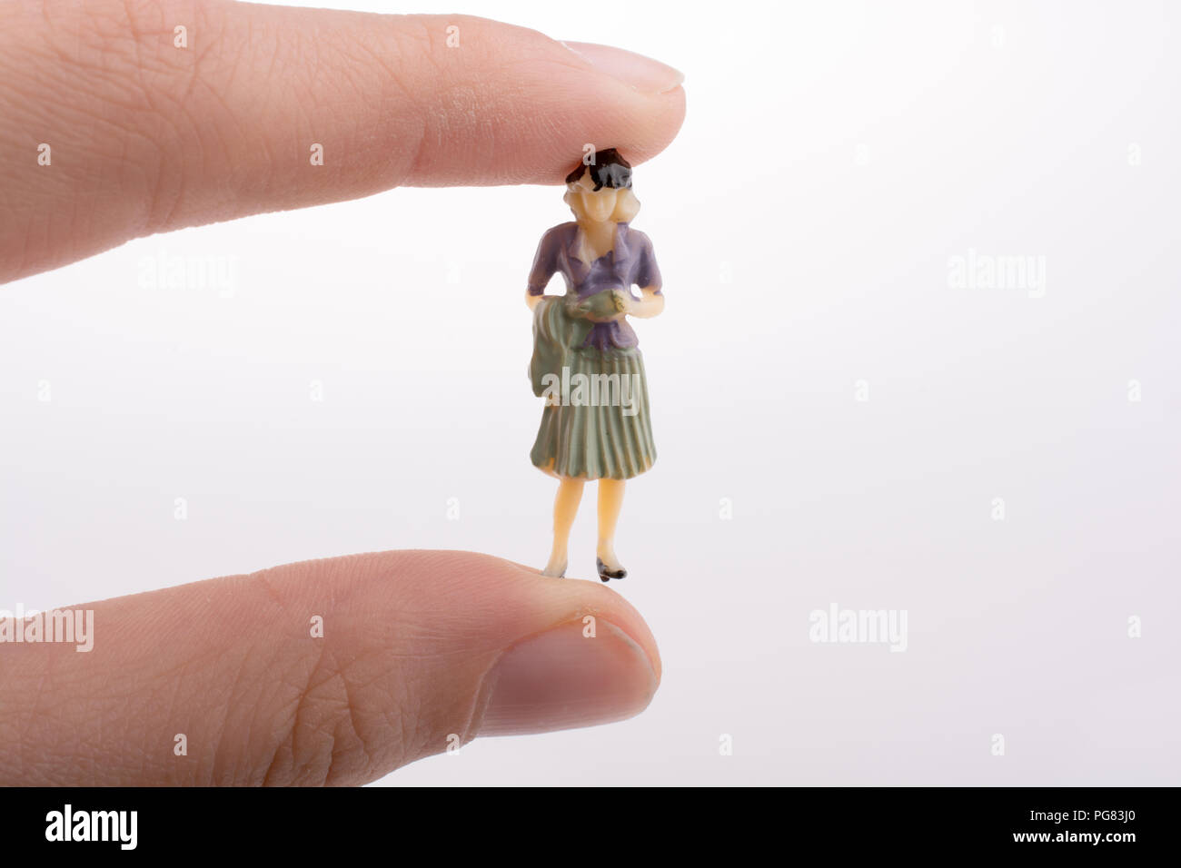 Hand holding a human figure on a white background Stock Photo - Alamy