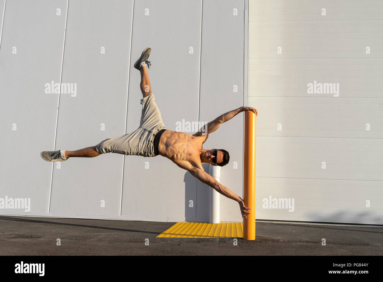 Acrobat training on a pole Stock Photo - Alamy