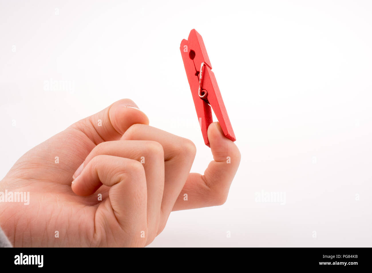 Hand holding a red clothespin on a white background Stock Photo - Alamy