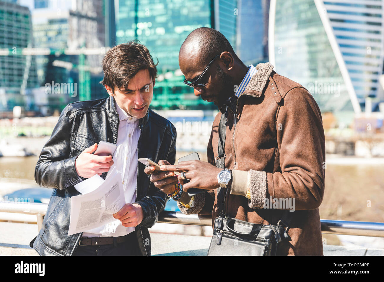 Two businessmen city looking cell phone hi-res stock photography and images - Alamy