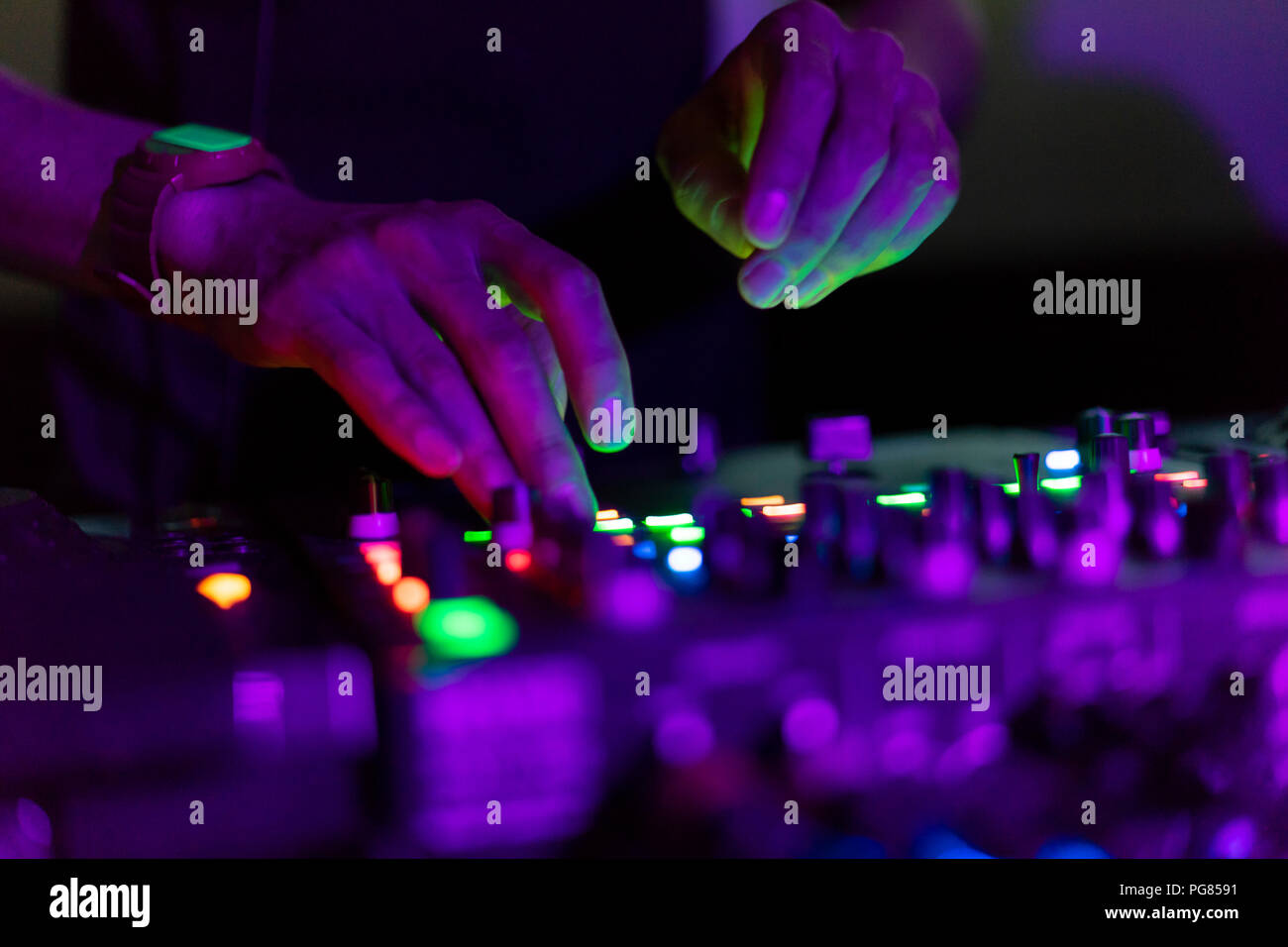 DJ working on mixing board Stock Photo - Alamy