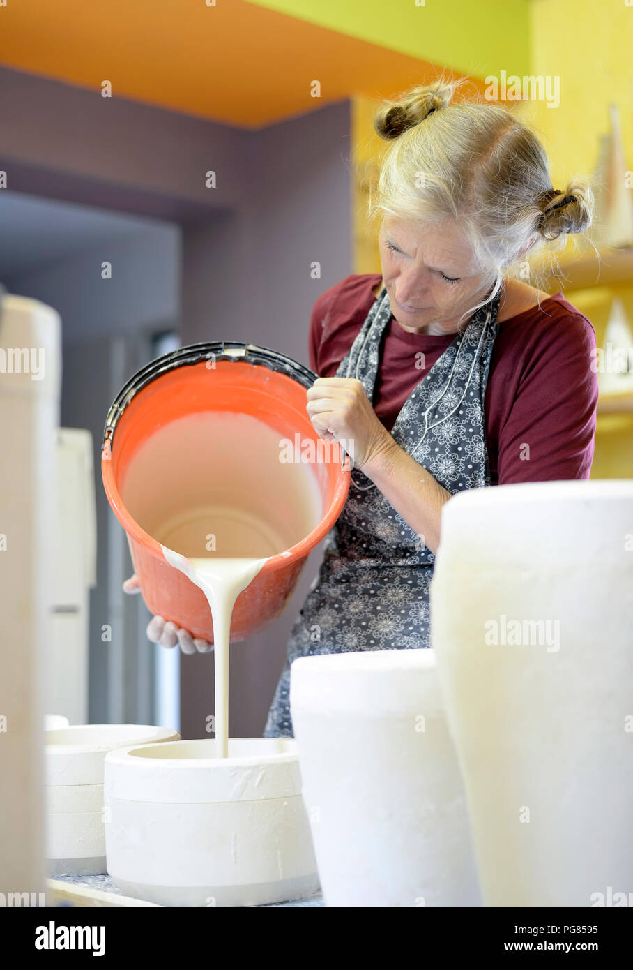 Woman pouring liquid into mold in porcelain workshop Stock Photo - Alamy