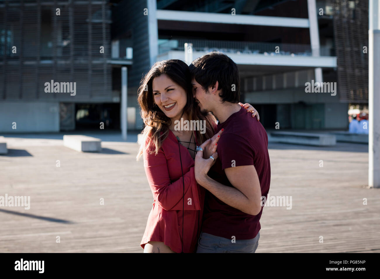Happy affectionate young couple standing on city square Stock Photo - Alamy