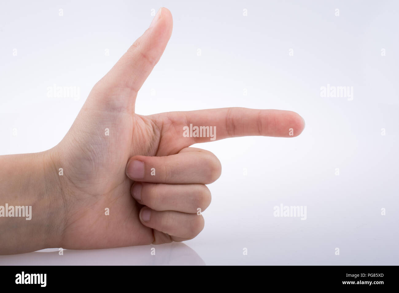 Hand making a gun gesture on a white background Stock Photo - Alamy