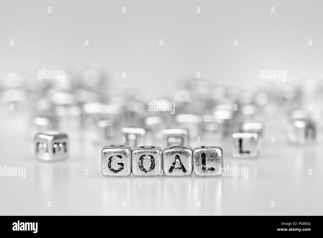 Goal word written on silver cube with black and white bokeh cube word ...