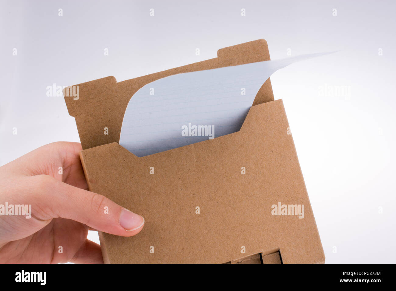 Hand reaches paper holder stand on white background Stock Photo - Alamy