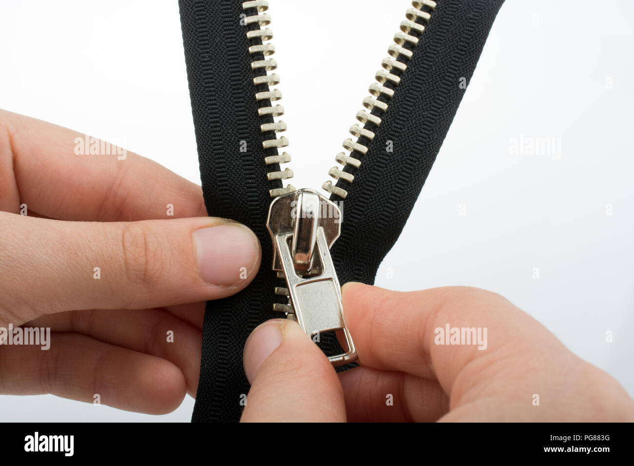 Hand holding color zipper on a white background Stock Photo - Alamy