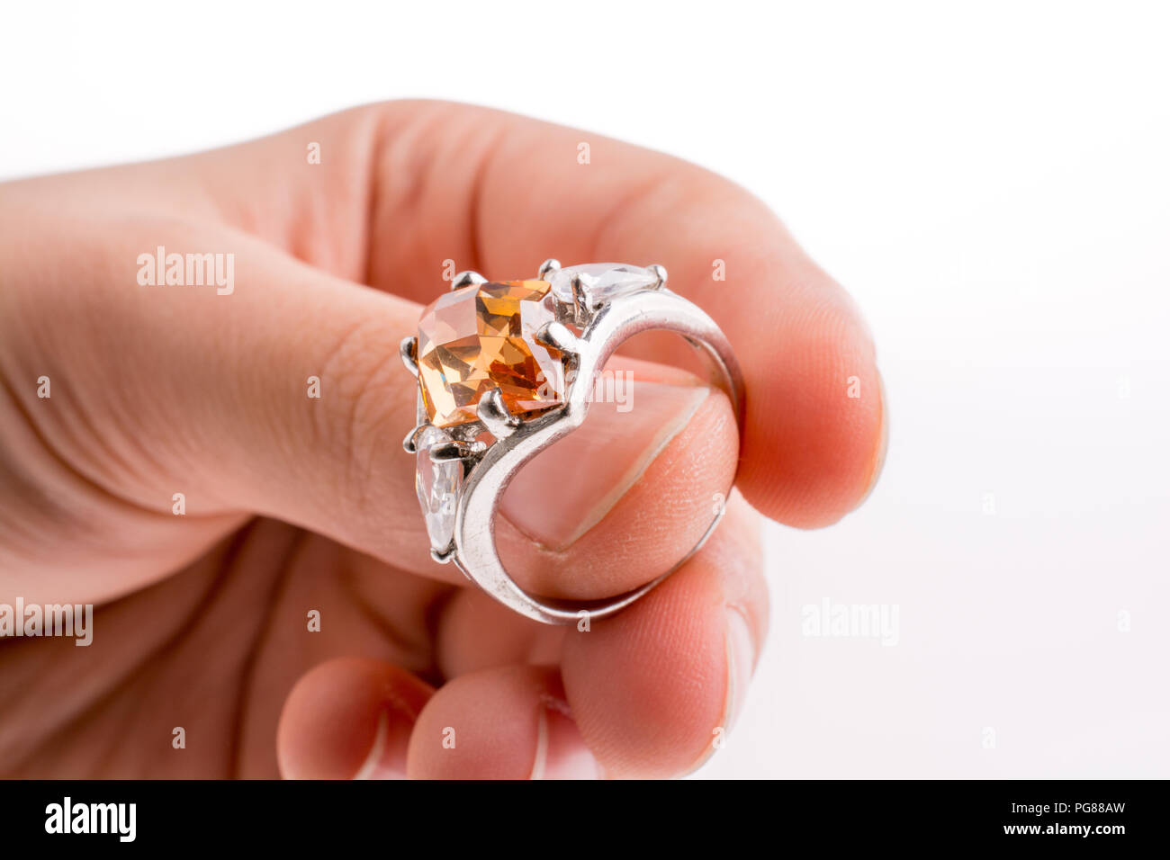 Hand holding a ring on a white background Stock Photo - Alamy