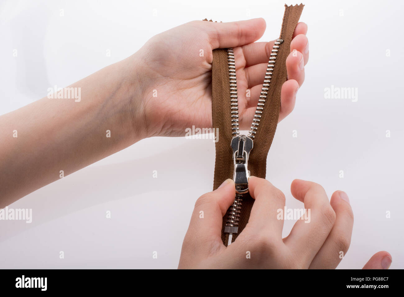 Hand holding color zipper on a white background Stock Photo - Alamy
