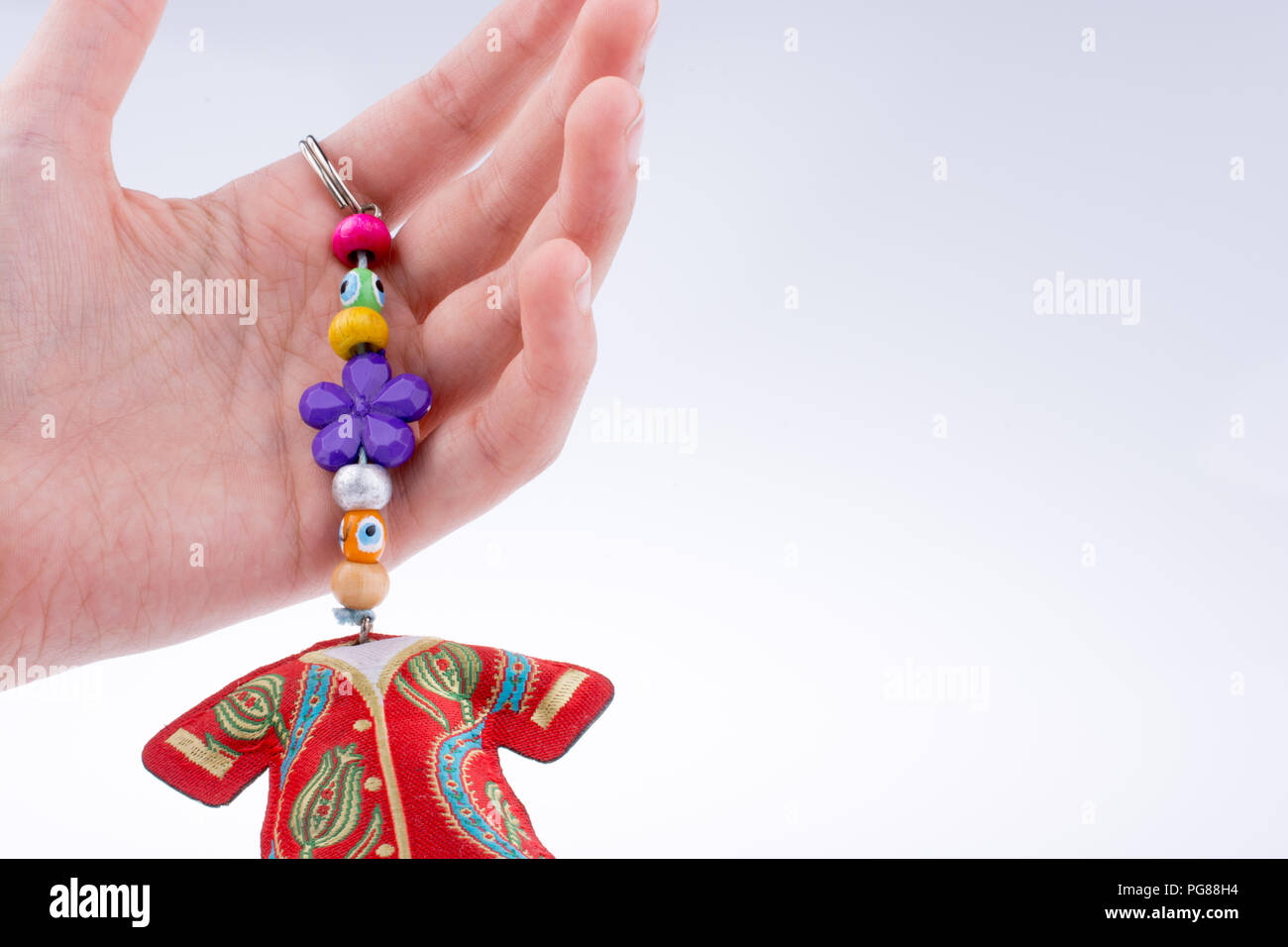 Hand holding traditional clothes with ornaments Stock Photo - Alamy