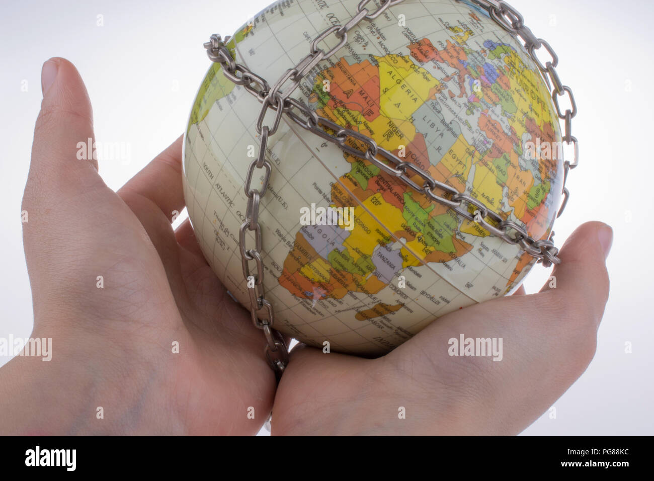 Hand holding a globe in chains Stock Photo - Alamy
