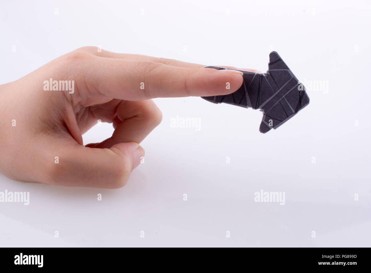 Hand holding a black arrow on a white background Stock Photo - Alamy