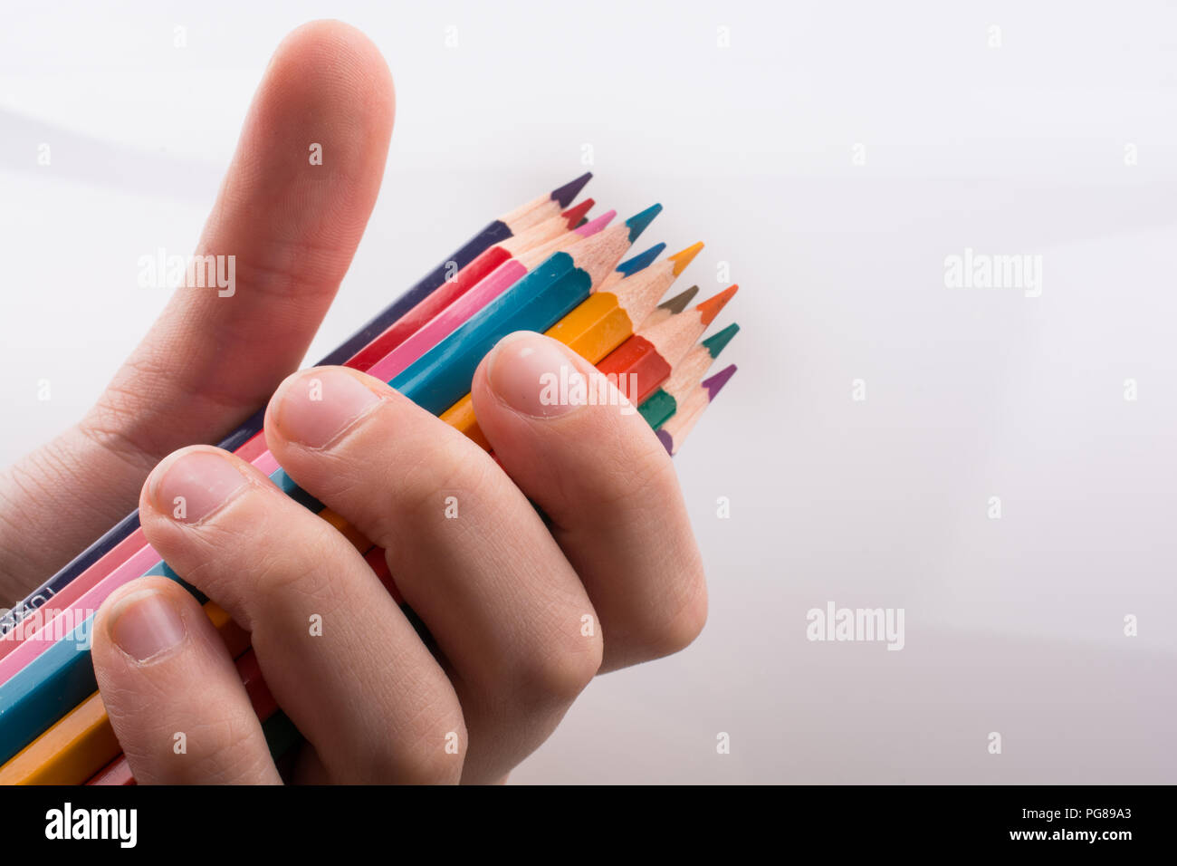 Hand holdin color pencils on a white background Stock Photo - Alamy