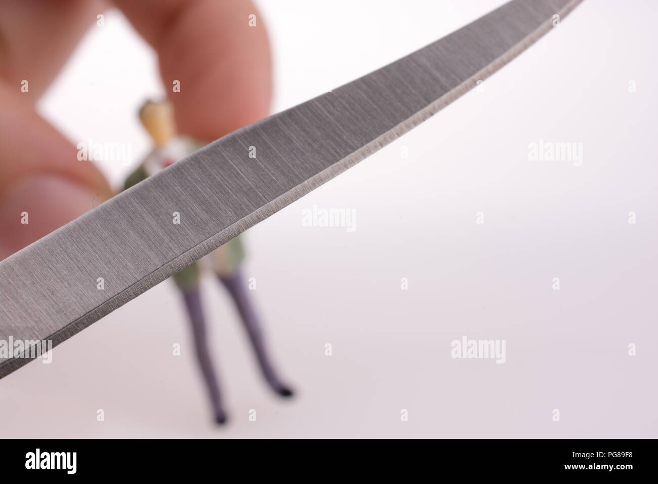 Hand holding a pocket knife near a human figure on a white background ...