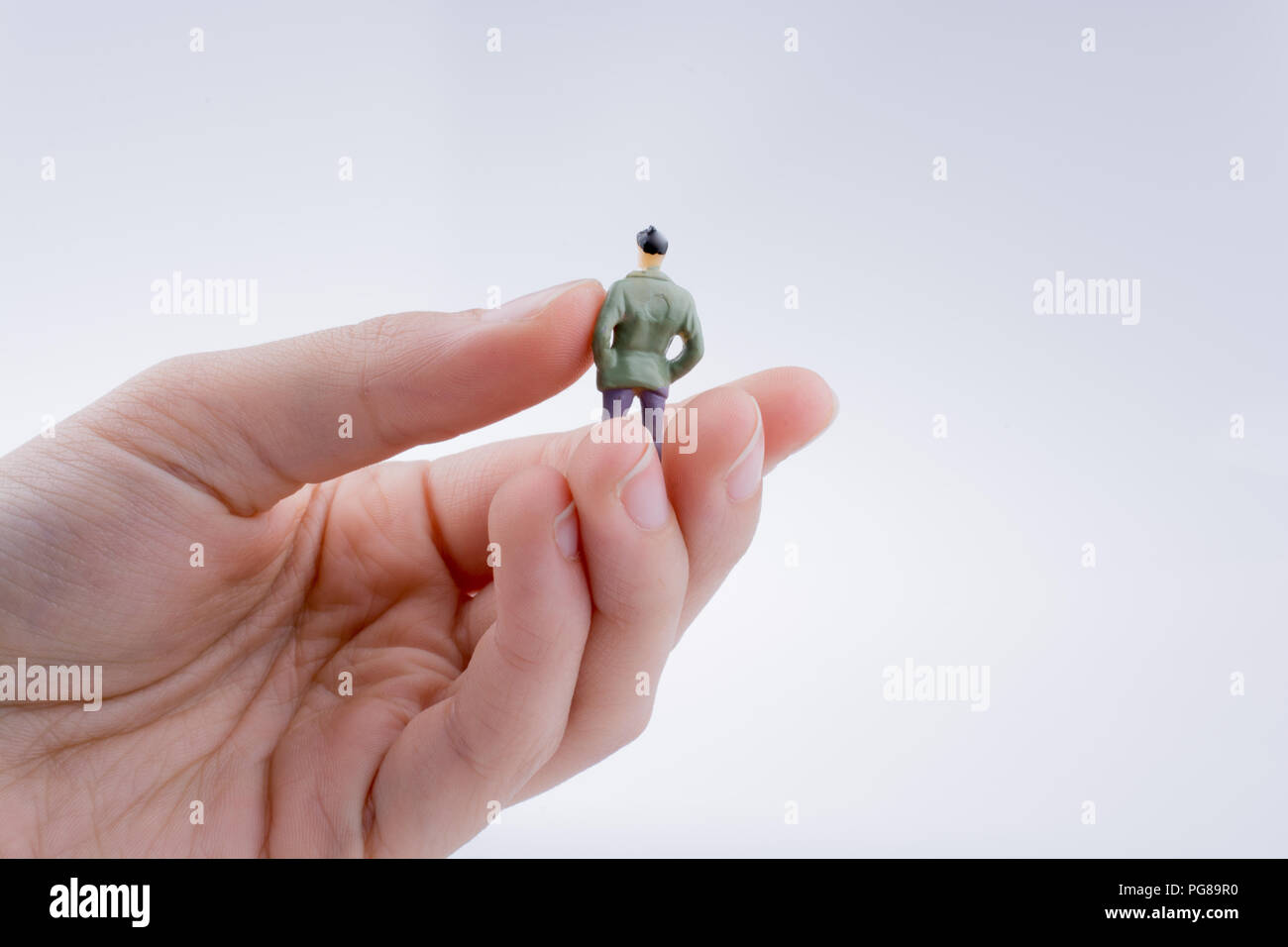 Hand holding a human figure on a white background Stock Photo - Alamy