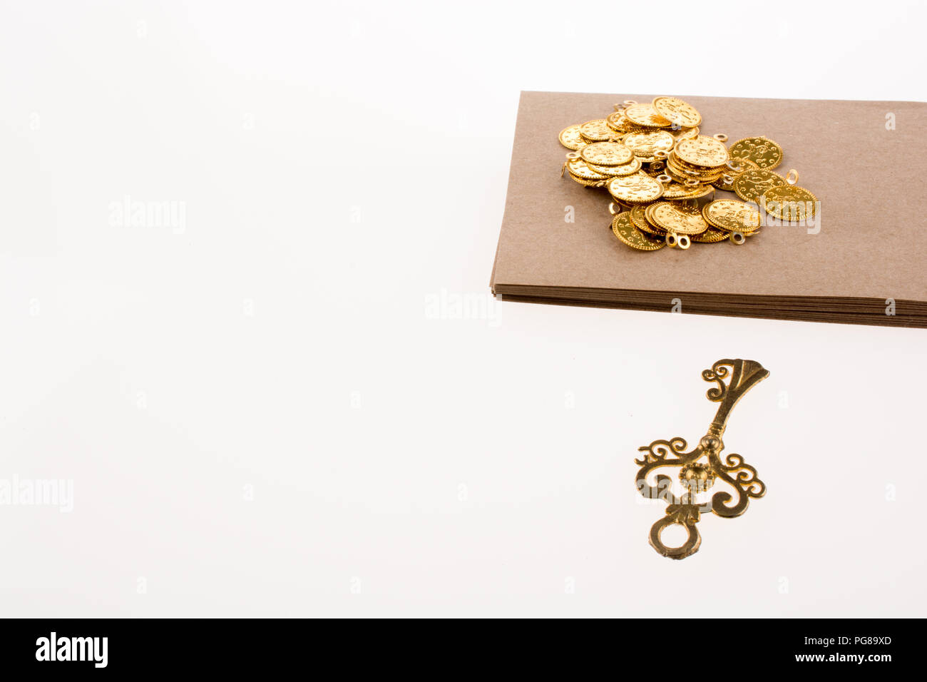 Fake gold coins, key and box on white background Stock Photo - Alamy