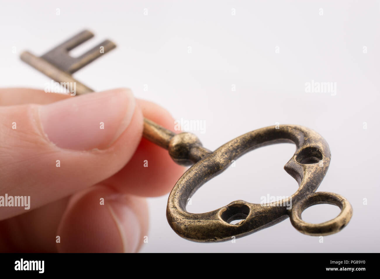 Hand holding a key on a white background Stock Photo - Alamy