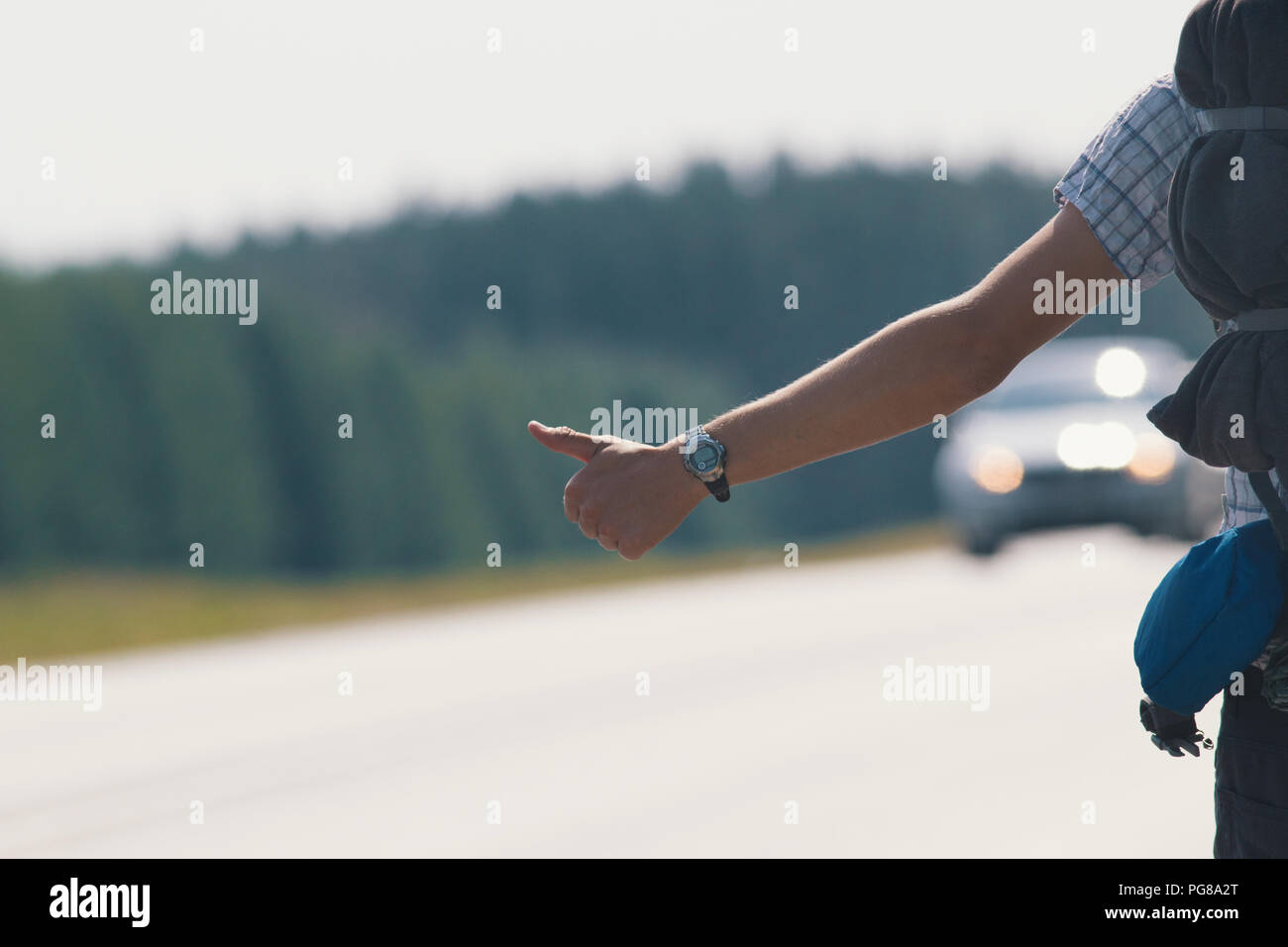 Hand of a young guy who honks on the road, hitchhiking Stock Photo - Alamy