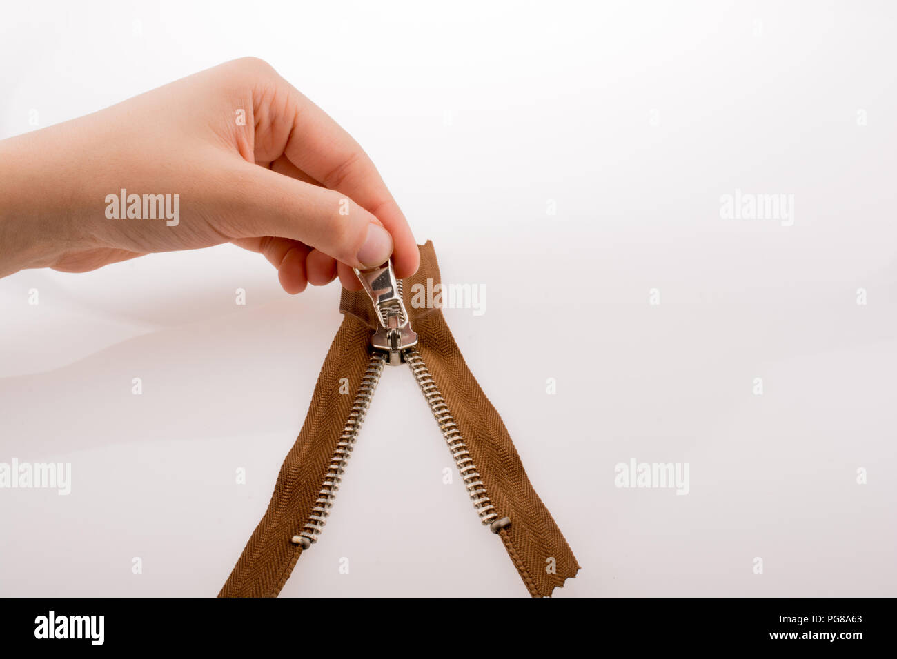 Hand holding color zipper on a white background Stock Photo - Alamy