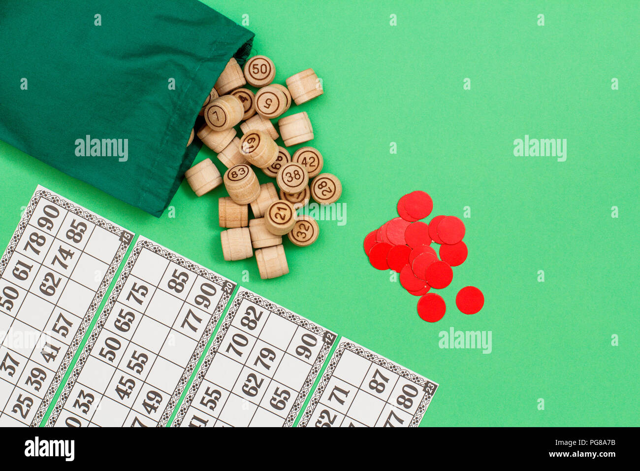 Wooden lotto barrels with cloth bag, game cards and red chips on green ...