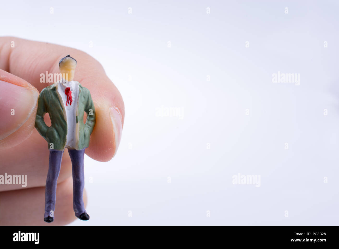 Hand holding a human figure on a white background Stock Photo - Alamy