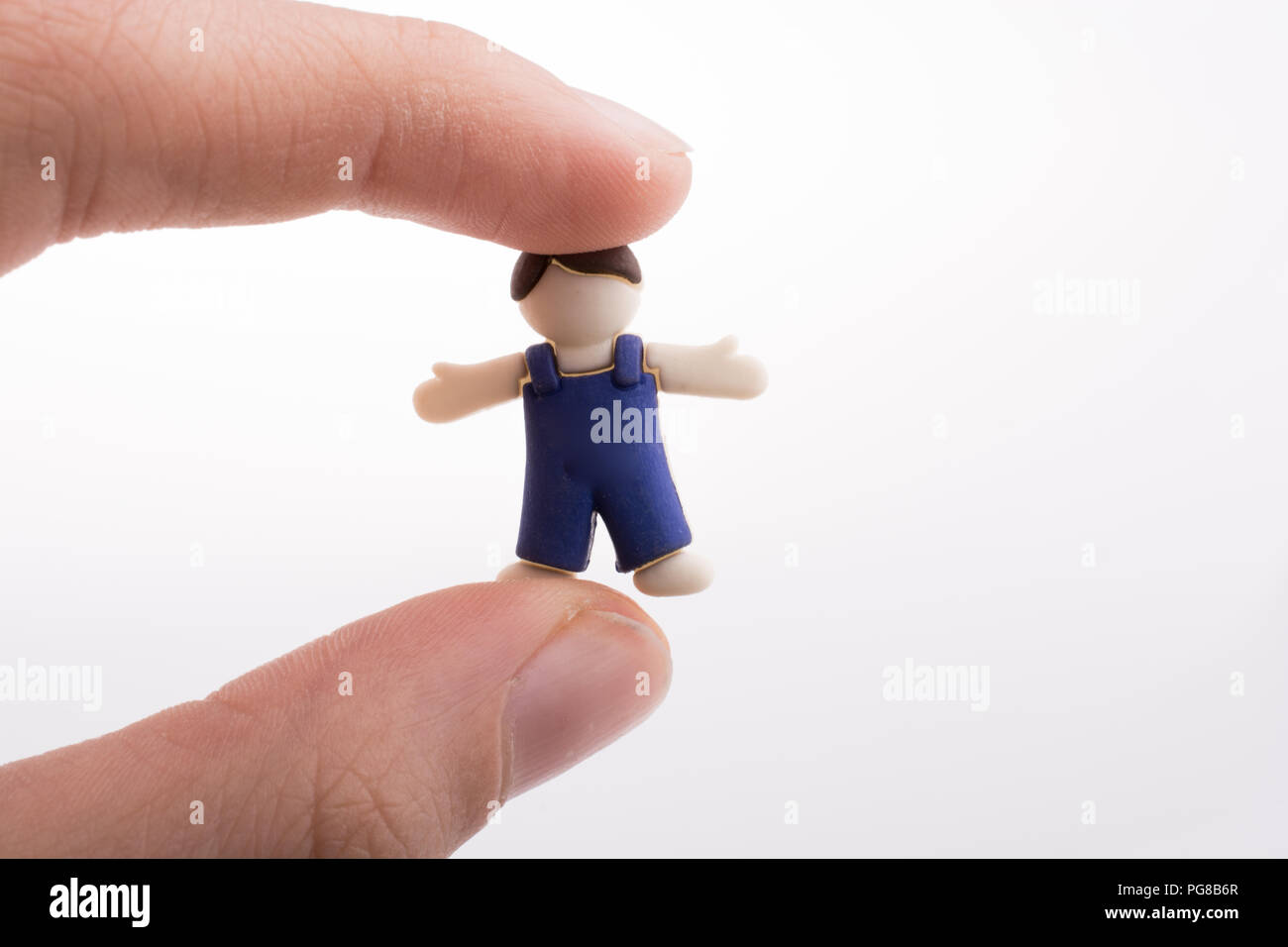 Hand holding a child figure on a white background Stock Photo - Alamy
