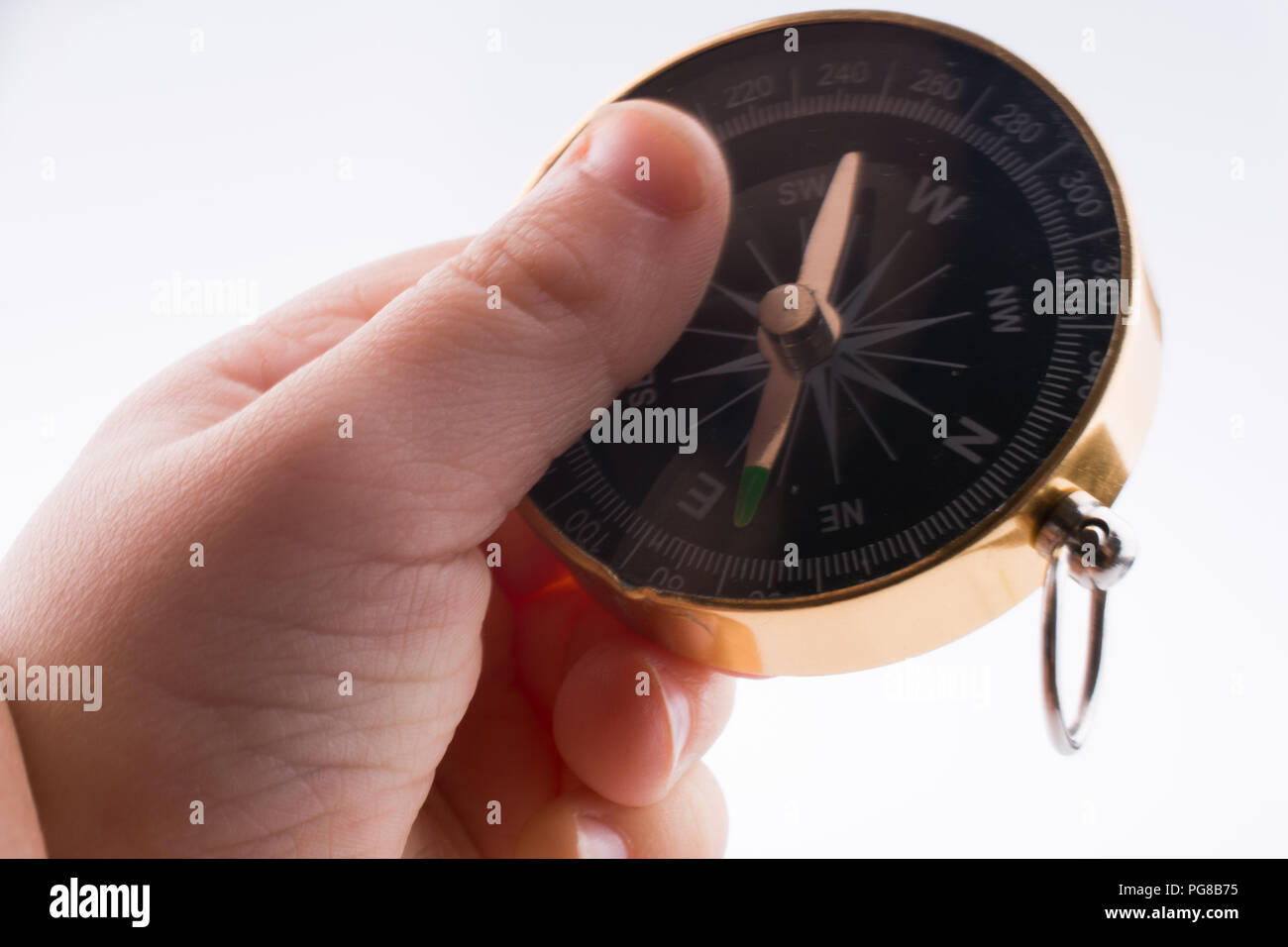 Hand holding a compass on a white background Stock Photo - Alamy