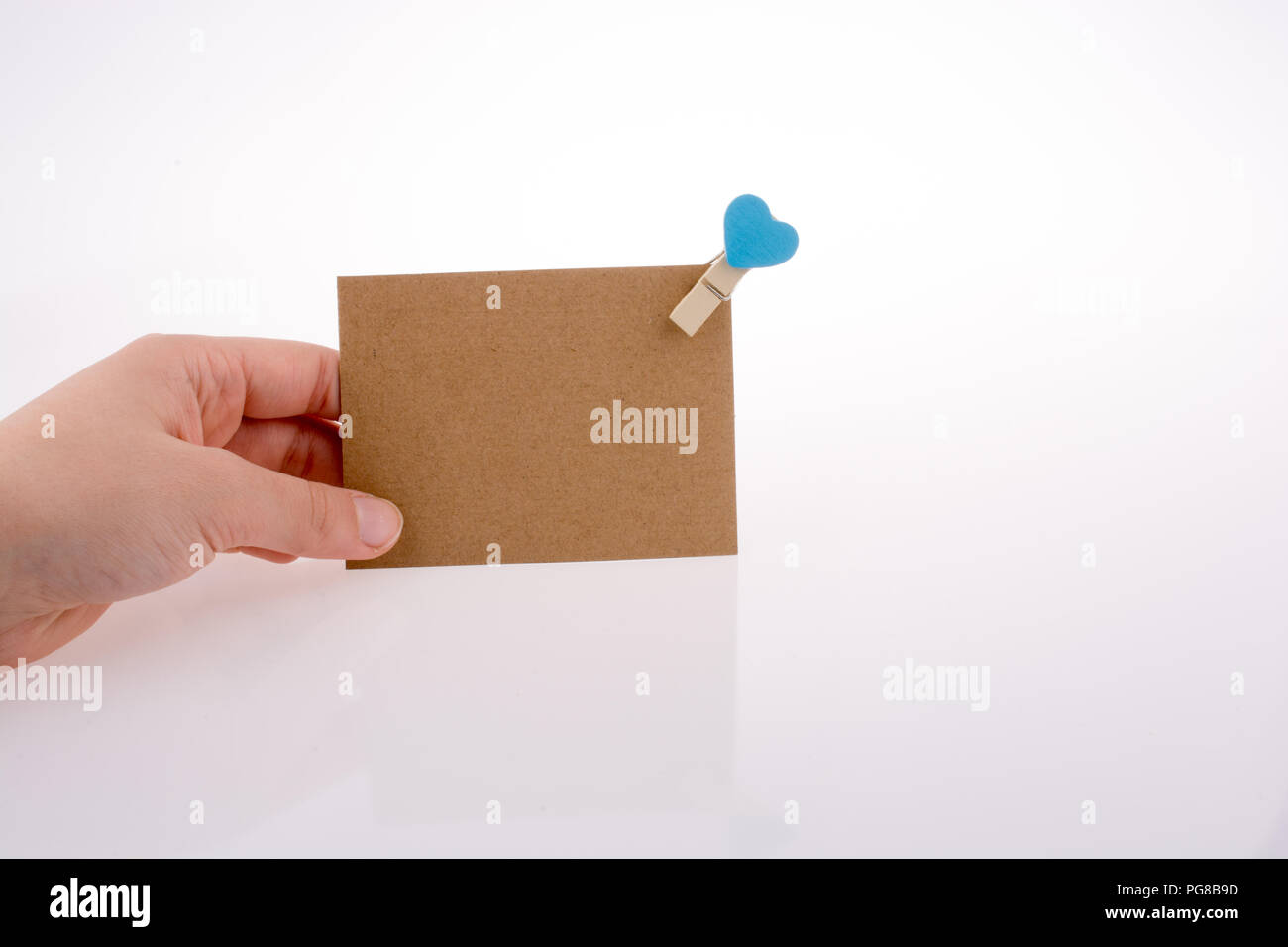 Hand holding a paper with a clip on it Stock Photo - Alamy