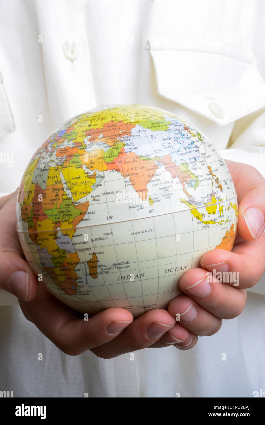 Child holding a small model globe in hand on white background Stock ...
