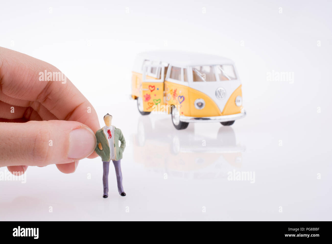 Hand holding a human figure near a peace van on a white background ...