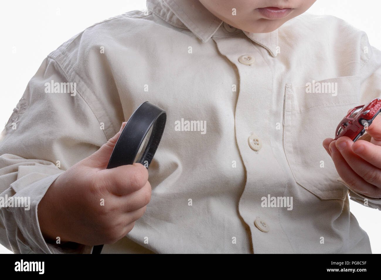 Baby holding a magnifying glass in hand on a white background Stock ...