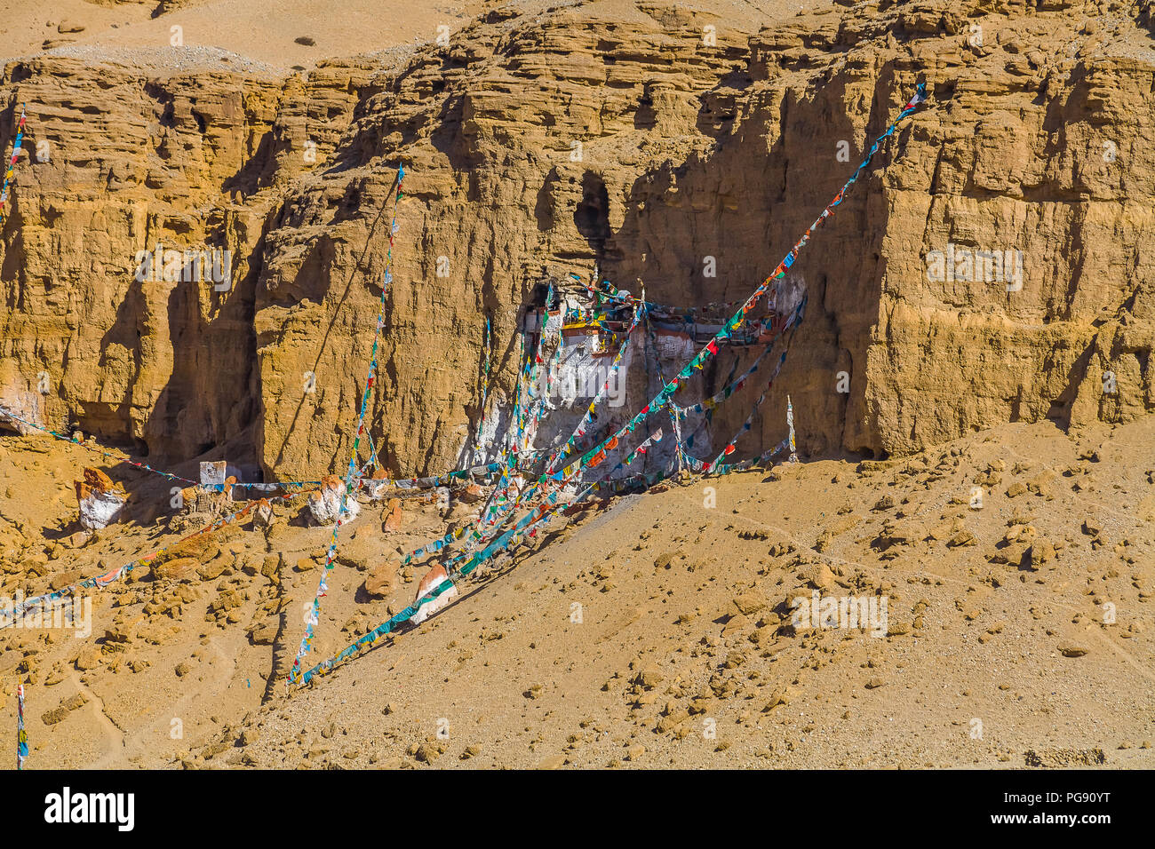 The cave hermitages of Guru Gyem Gompa, and fluttering prayer flags ...