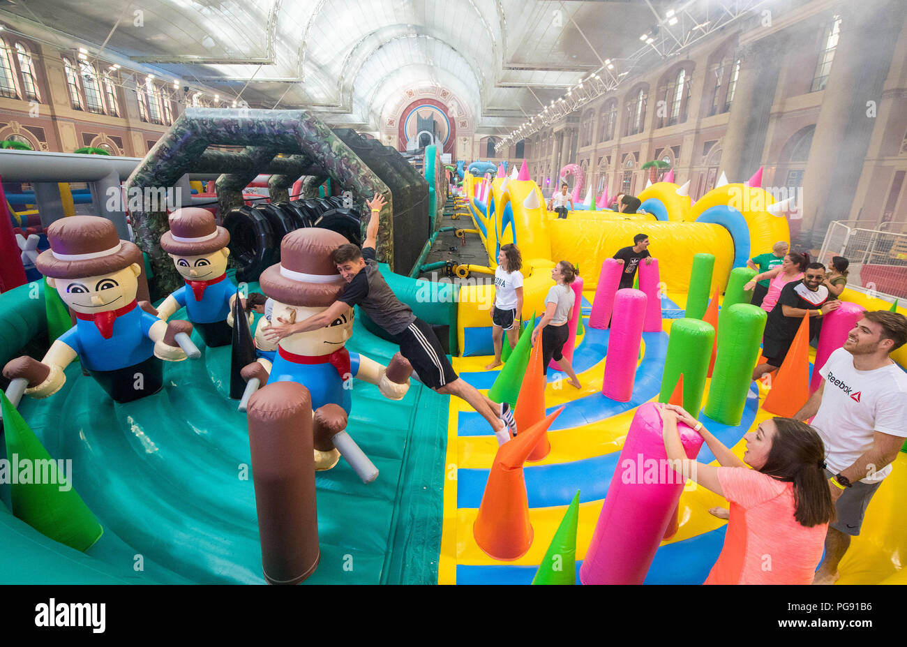 People tackle The Monster, a 300 metre long inflatable obstacle course ...