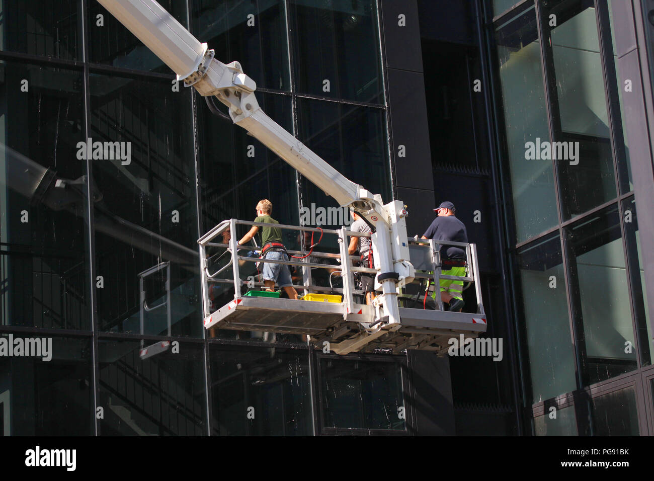 Window cleaners working on a modern high rise glass building Stock ...