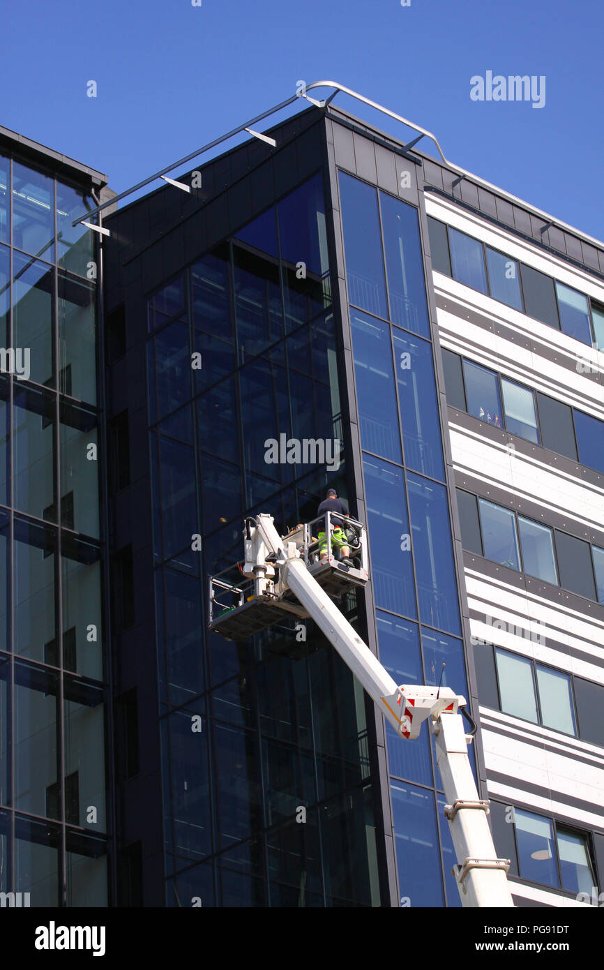Window cleaners working on a modern high rise glass building Stock ...