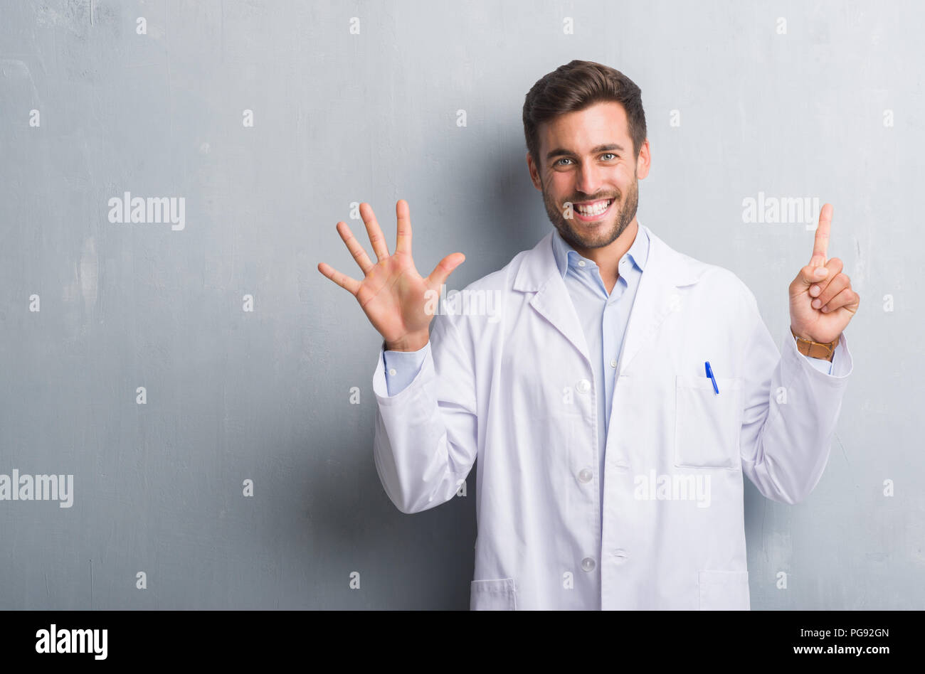 Handsome young professional man over grey grunge wall wearing white ...