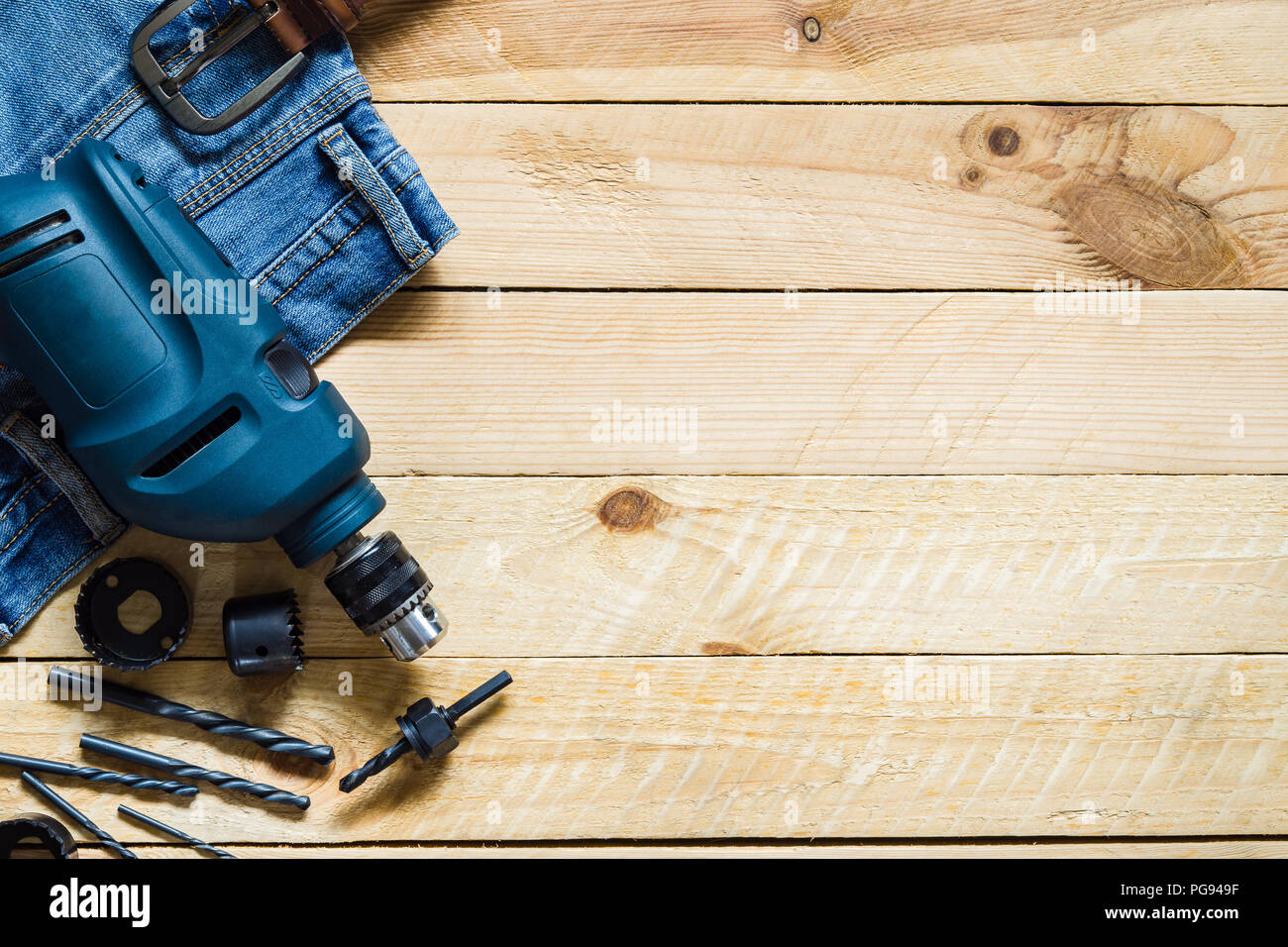 blue electric power drill with set of bit and blue jeans on gruge ...