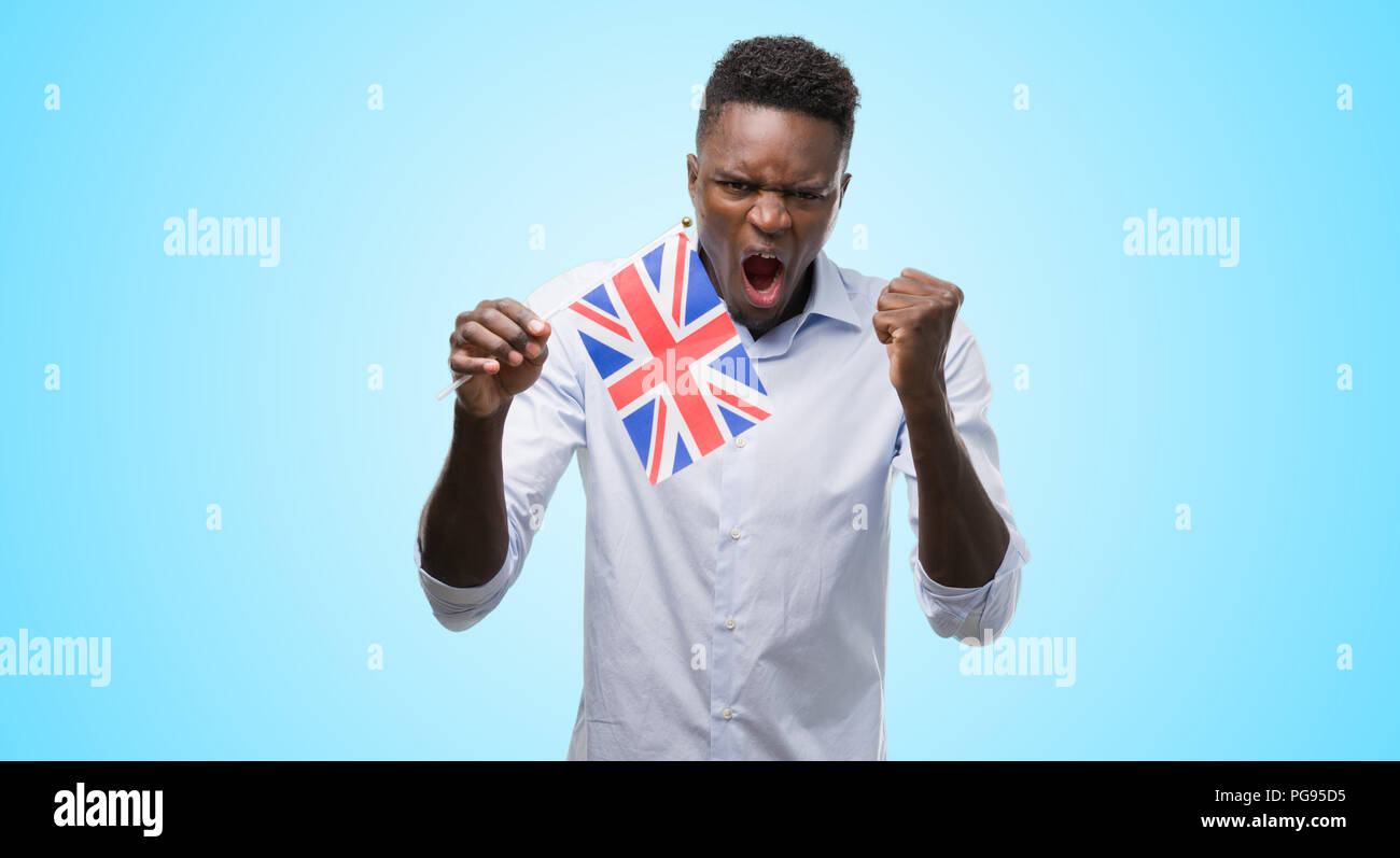 Young african american man holding United Kingdom flag annoyed and ...