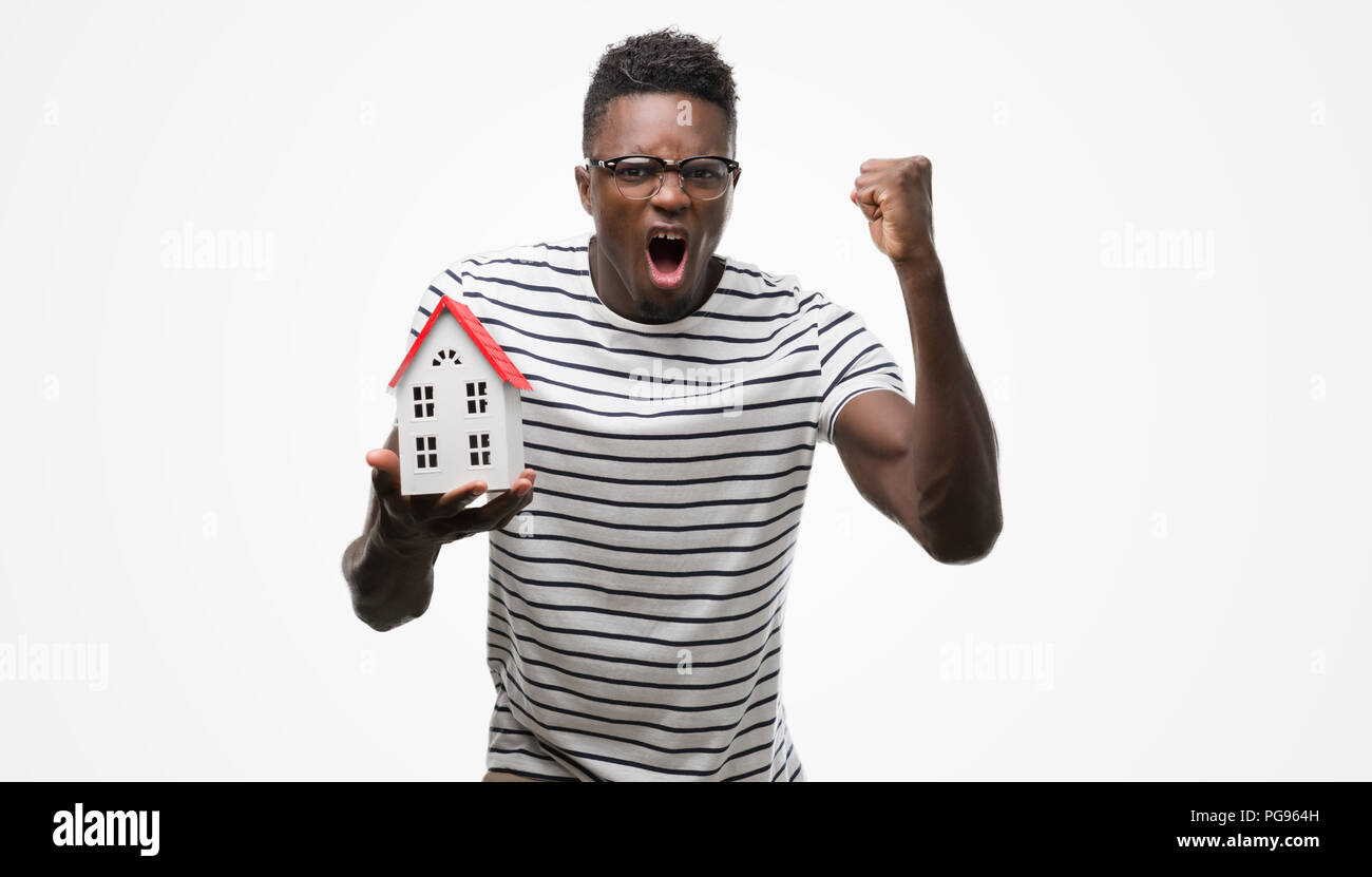 Young african american man holding house annoyed and frustrated ...