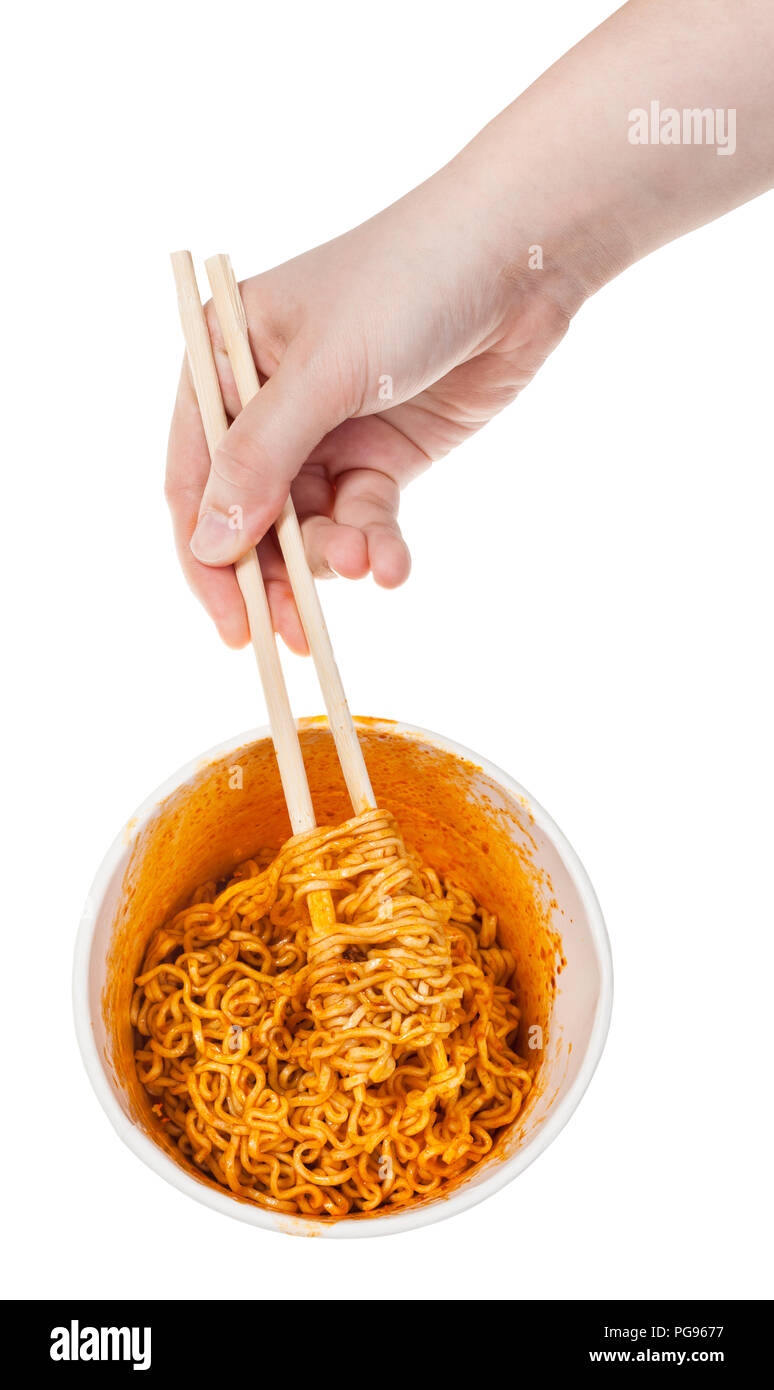 hand keeps wooden chopsticks in cooked spicy instant noodles isolated ...