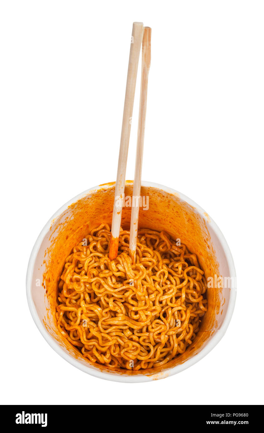 top view of wooden chopsticks in cup with cooked spicy instant noodles ...