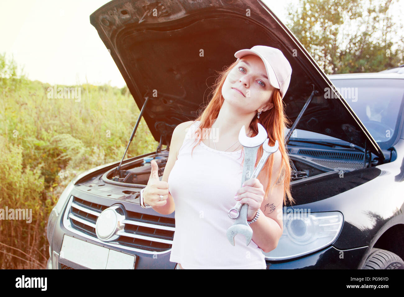 Wait for roadside assistance.Portrait of a young woman standing next to ...