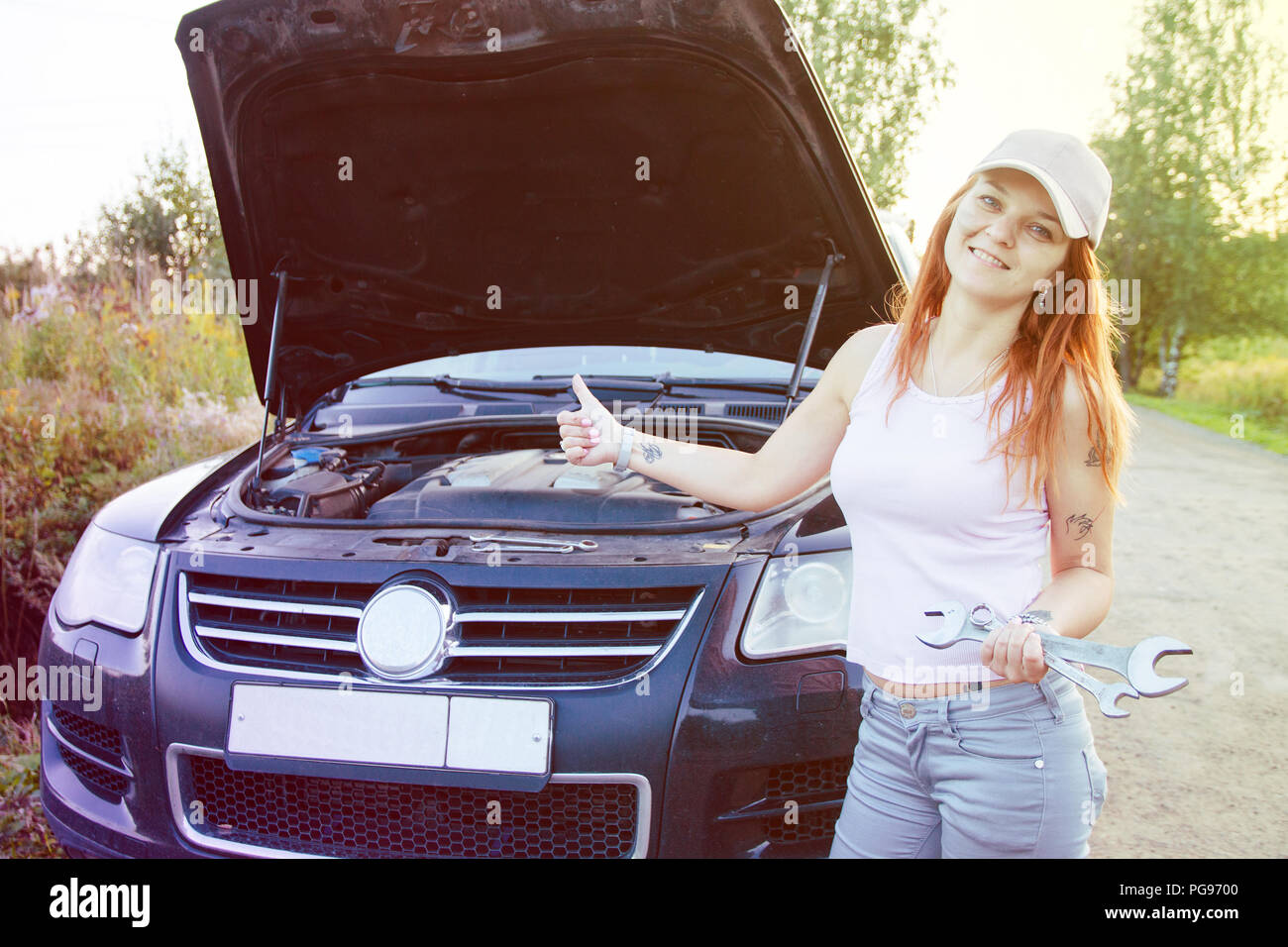 Wait for roadside assistance.Portrait of a young woman standing next to ...