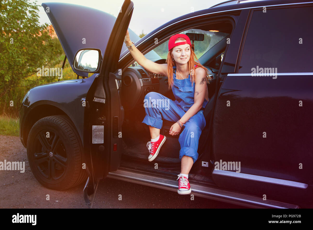 Wait for help on the road. Portrait of a young woman sitting in her car ...