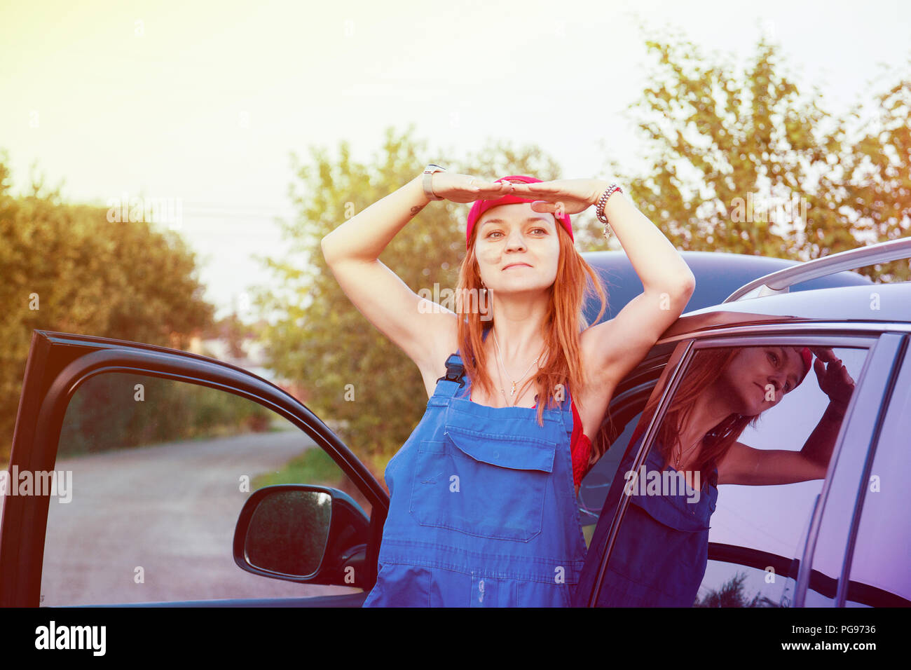 Wait for help on the road. Portrait of a young woman in working form ...